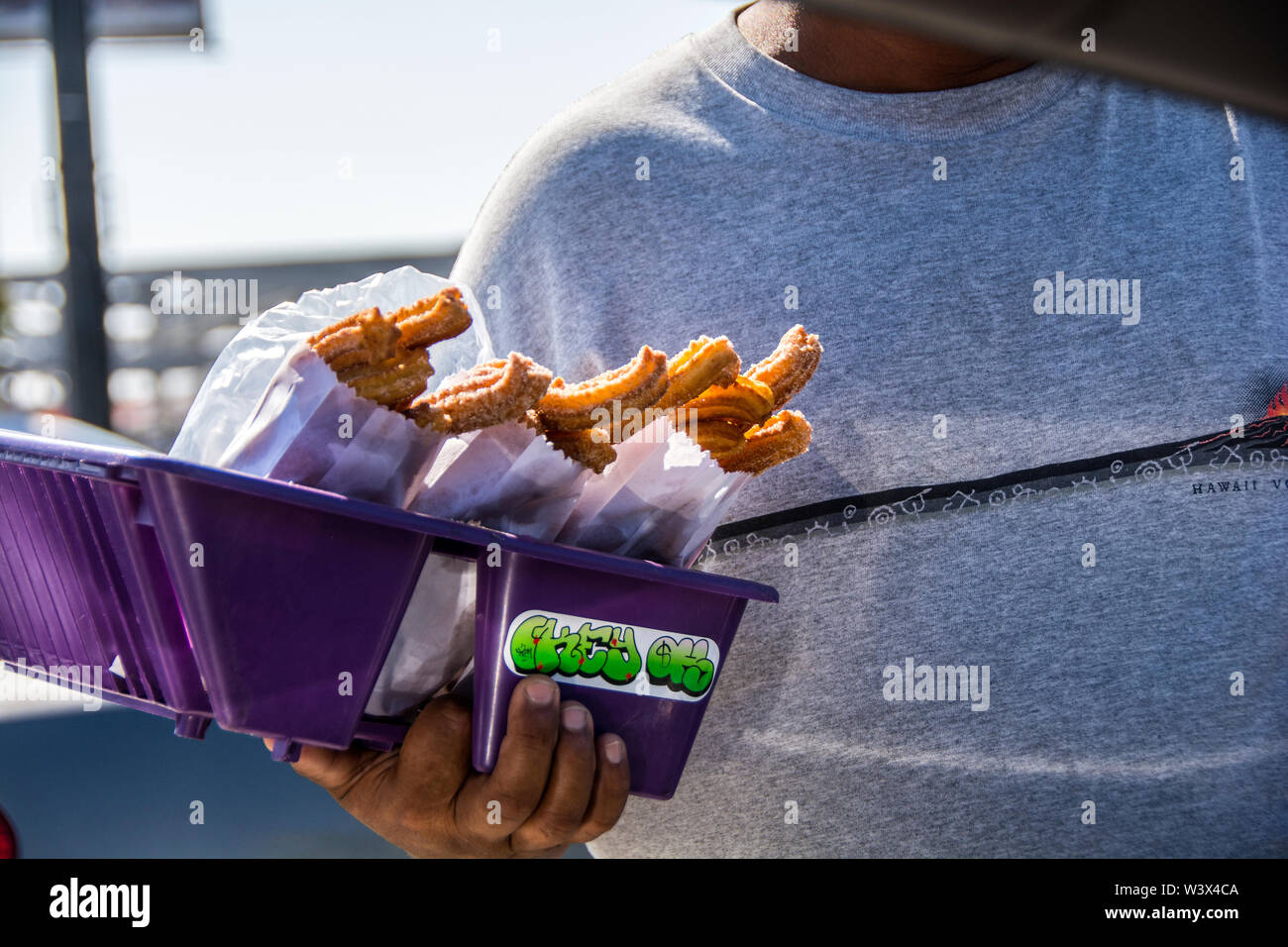 A Mexican vender, selling churros, a type of sweet bread, to tired ...