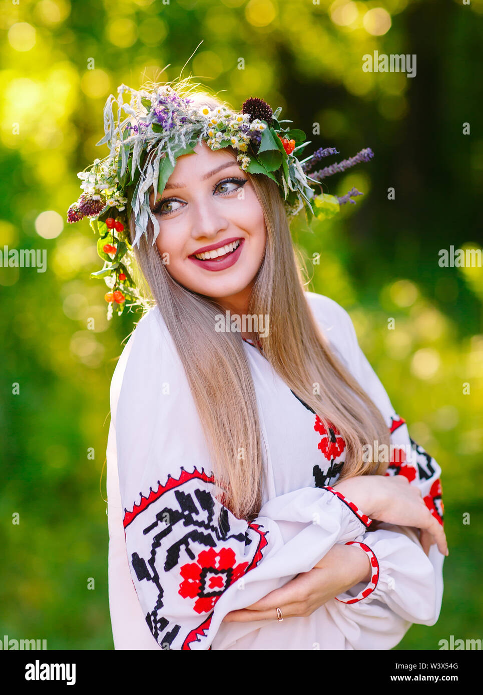 A young girl of Slavic appearance with a wreath of wild flowers on the ...