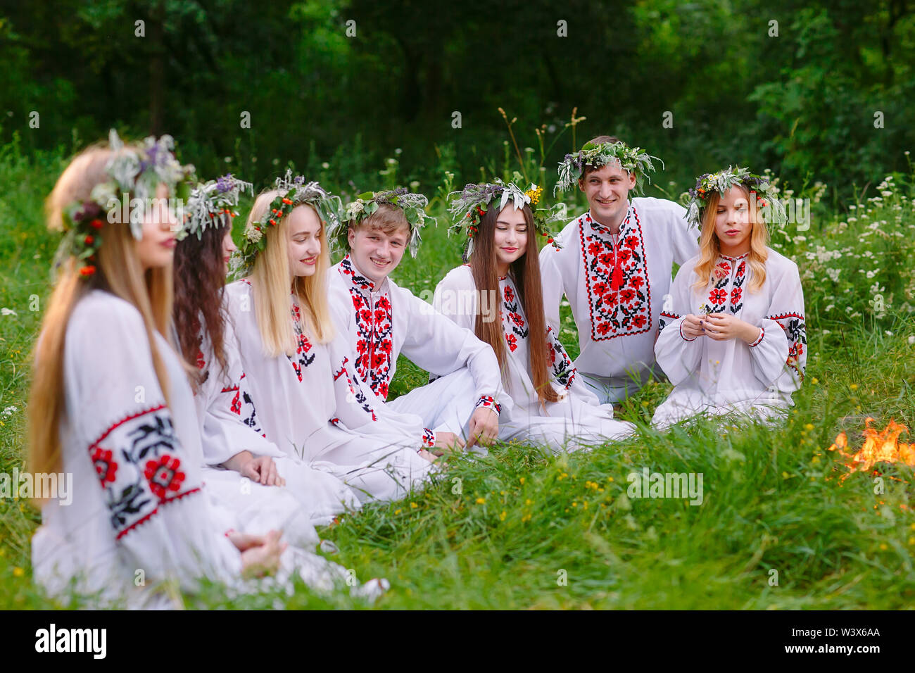 Midsummer. Group of young people of Slavic appearance are sitting ...