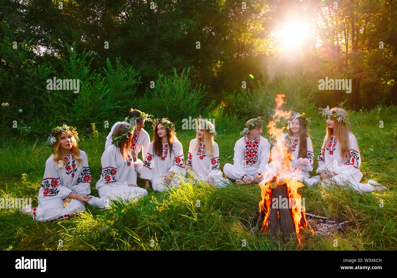 Midsummer. Group of young people of Slavic appearance are sitting ...