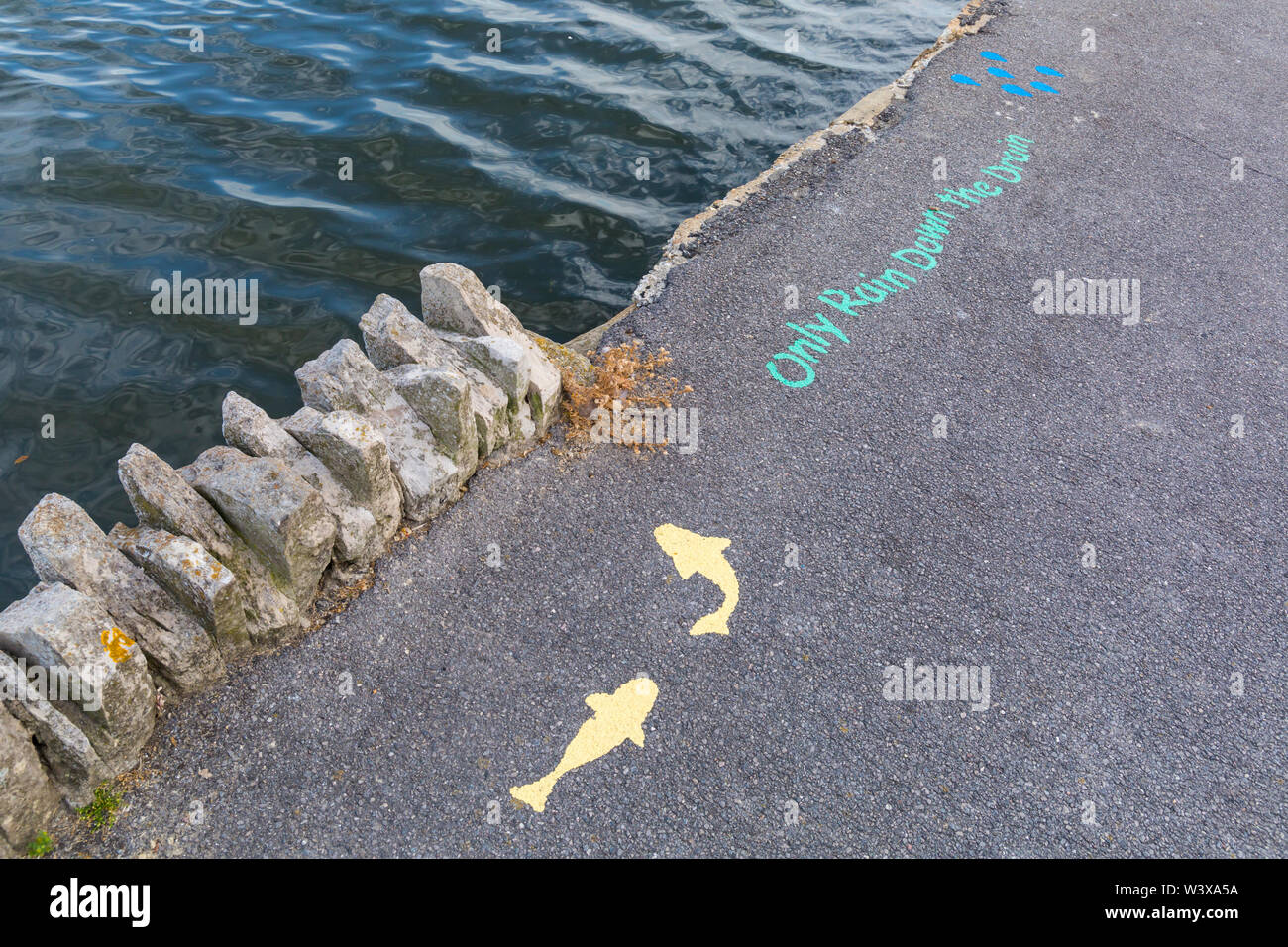 Only rain down the drain painted on walkway alongside Poole Lake in ...