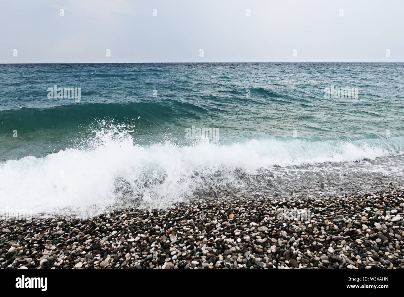 Pebble beach and blue sea Stock Photo - Alamy