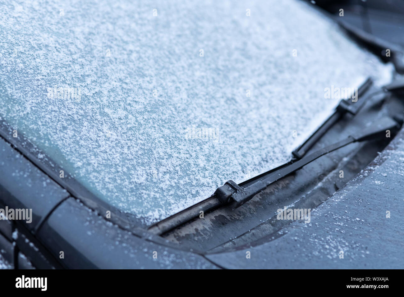 Snow covered car window with wipers, macro, close up. Antifreeze was ...