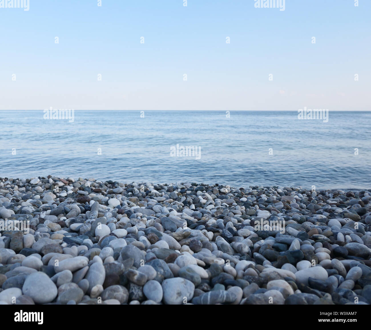 Pebble beach and blue sea Stock Photo - Alamy