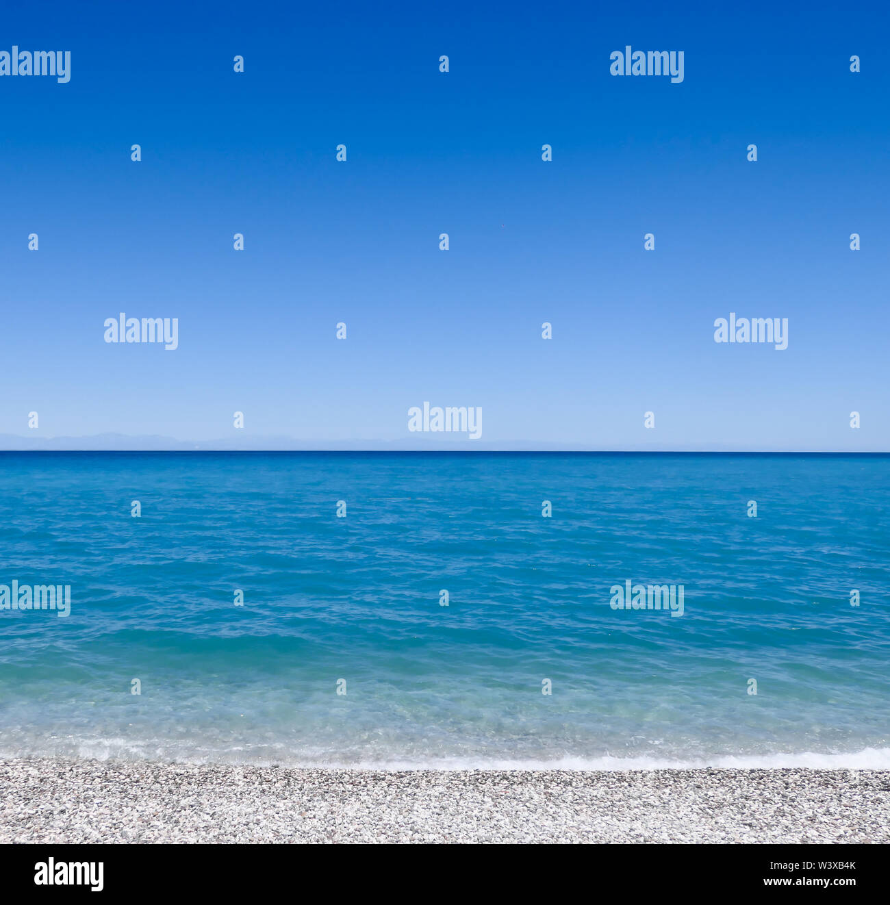 Pebble beach and blue sea Stock Photo - Alamy