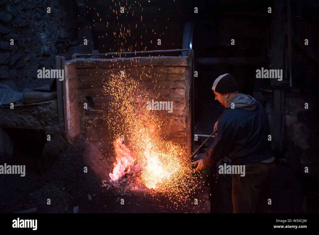 young traditional Blacksmith working with open fire The blacksmith ...