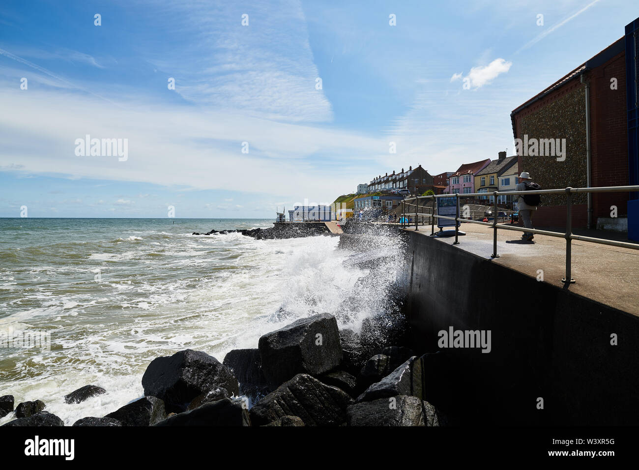 Waves and spray from the North Sea hit the sea wall and rocks at ...