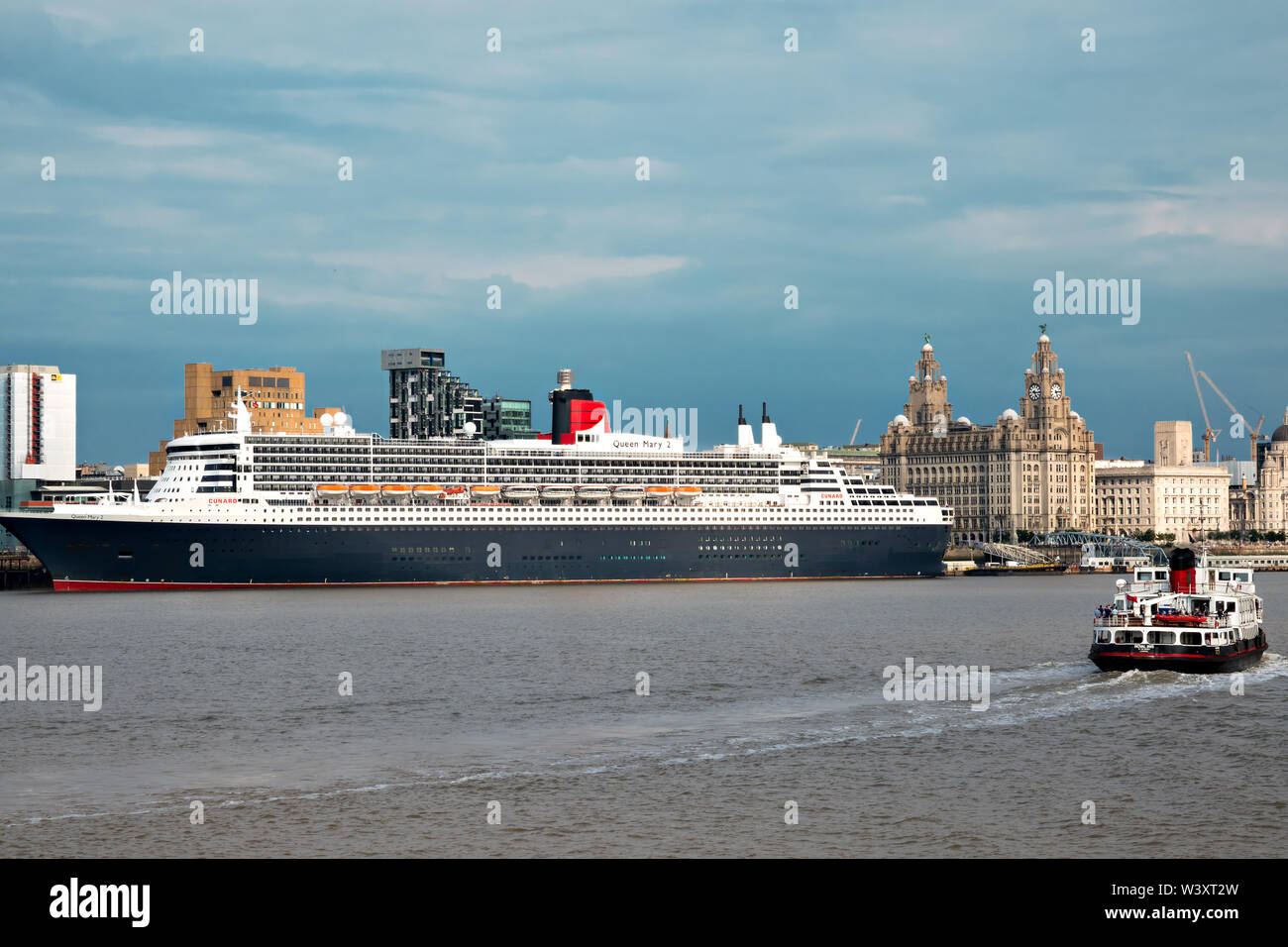 The Mersey Ferry Royal Iris passing in front of the Queen Mary 2 docked ...