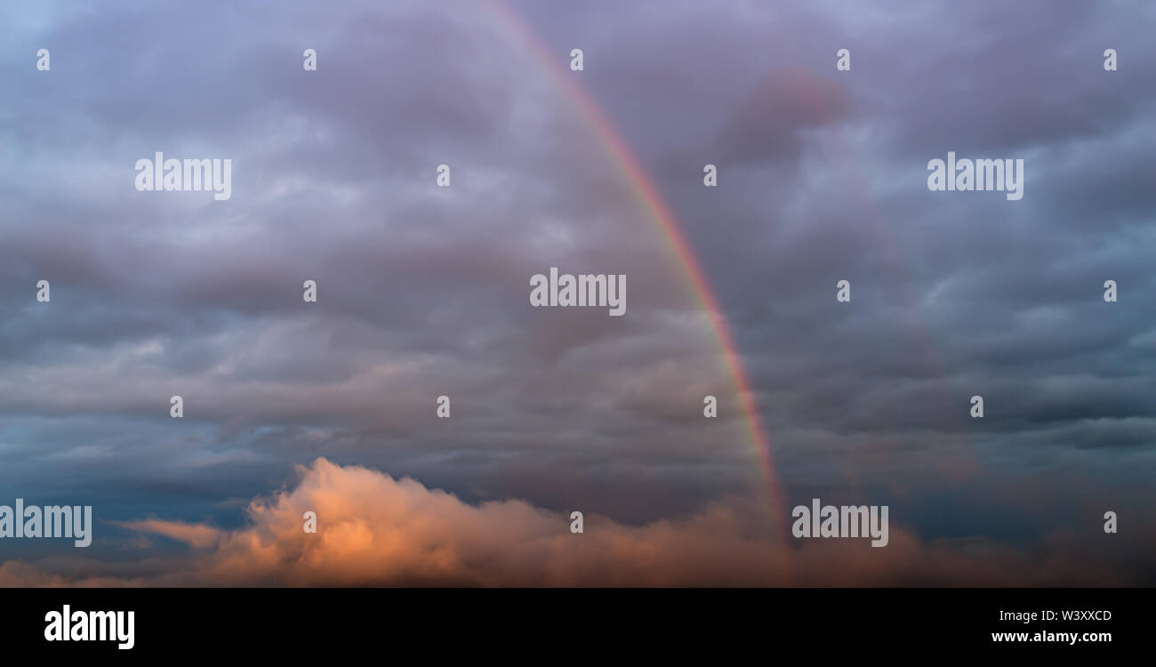 Natural colorful rainbow in clouds Stock Photo - Alamy