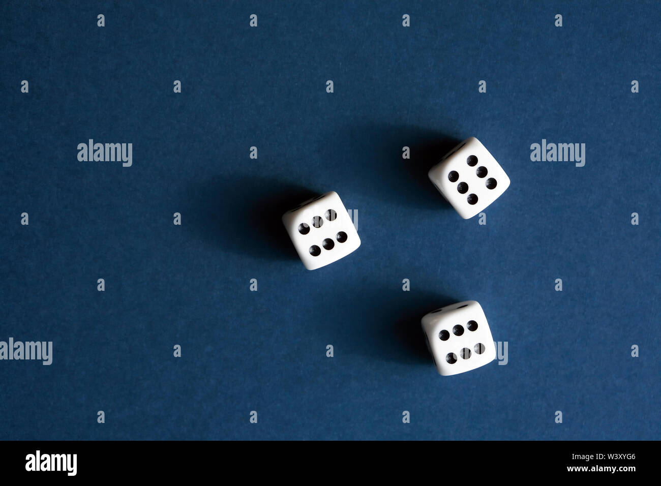 Three dice cubes on blue background with free space Stock Photo - Alamy