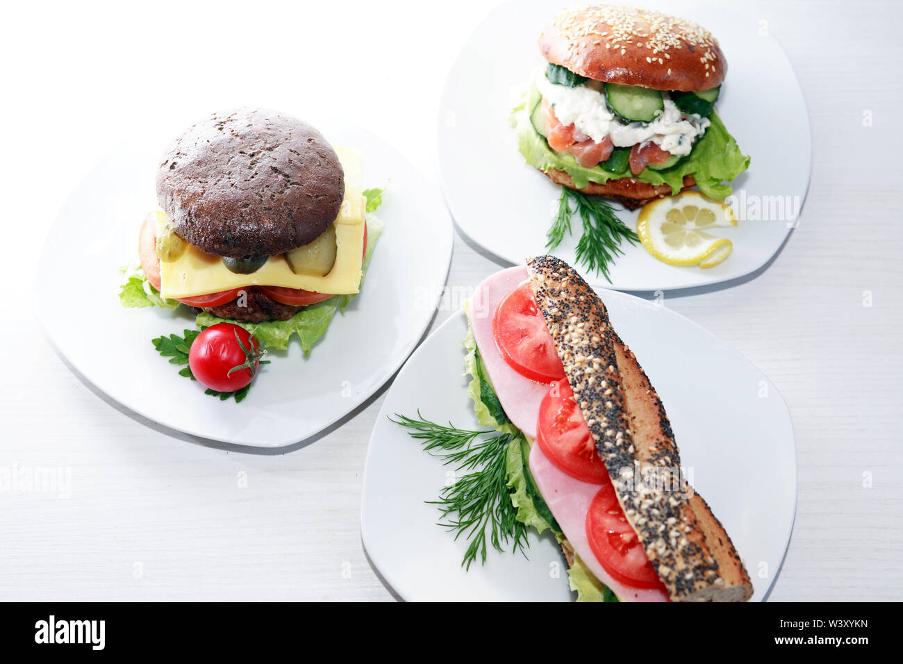 Various sandwiches on plates against white background Stock Photo - Alamy