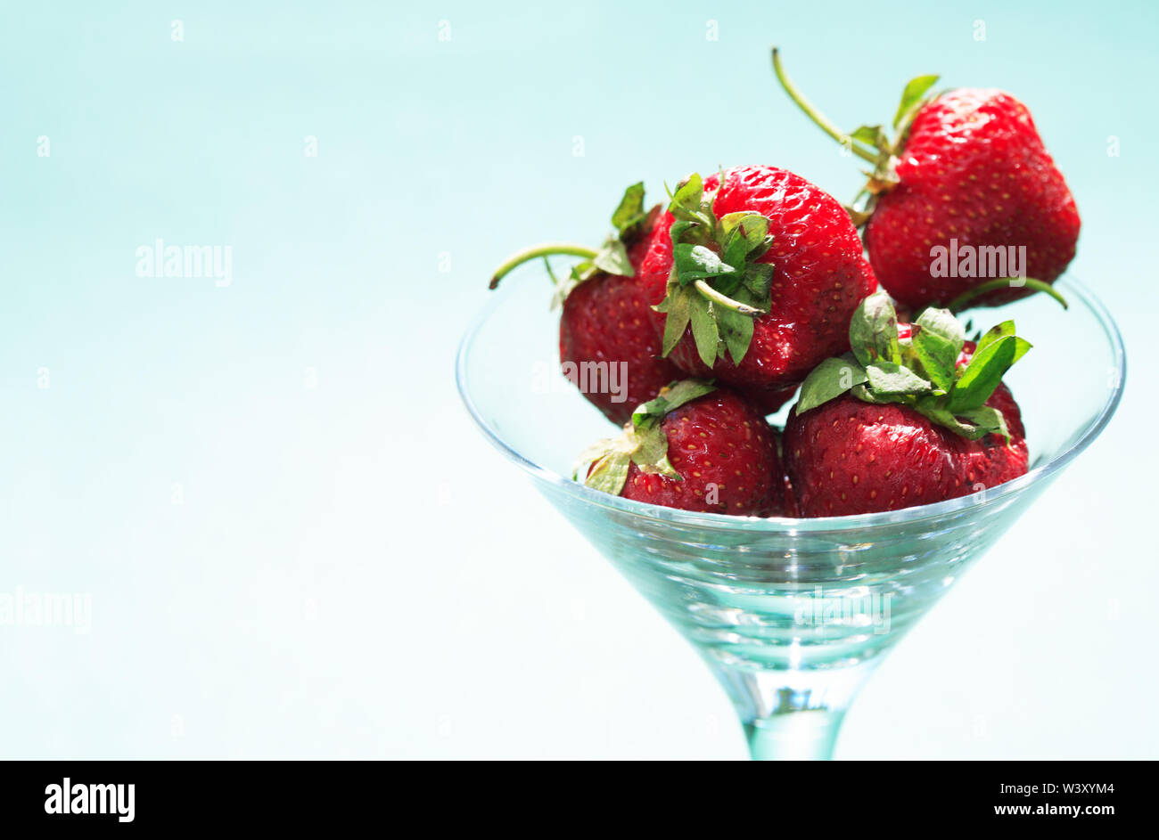 Few strawberry fruits in nice glass bowl Stock Photo - Alamy