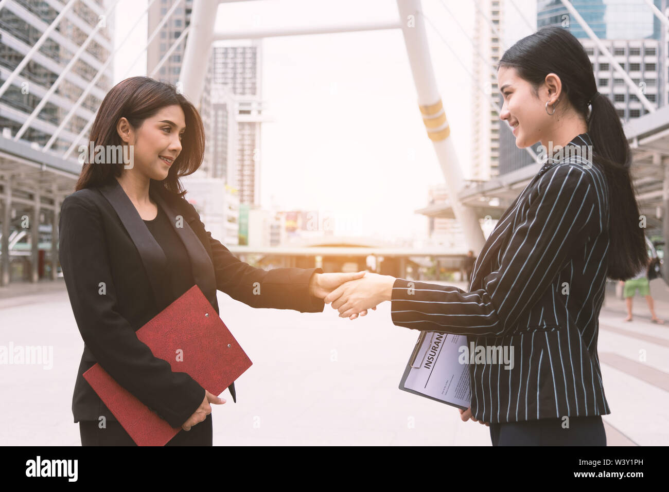 Two women making handshake greeting each other in group meeting at ...