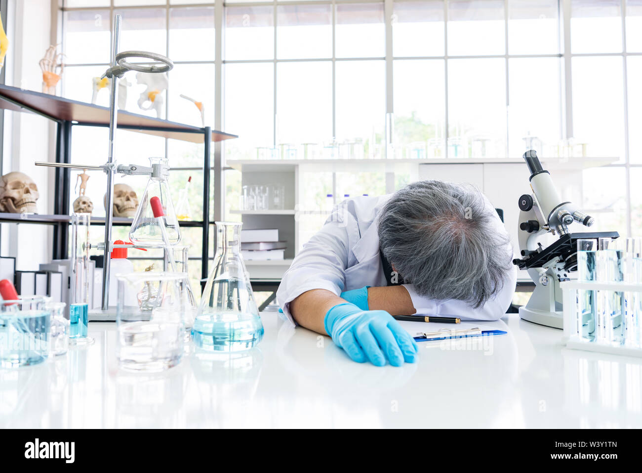 Exhausted scientist sleeping in laboratory. People lifestyles and ...