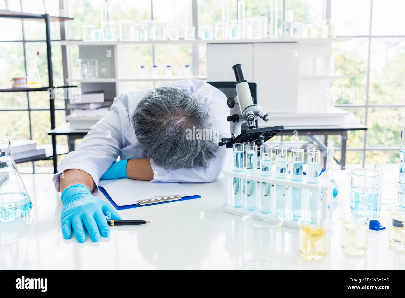Exhausted scientist sleeping in laboratory. People lifestyles and ...