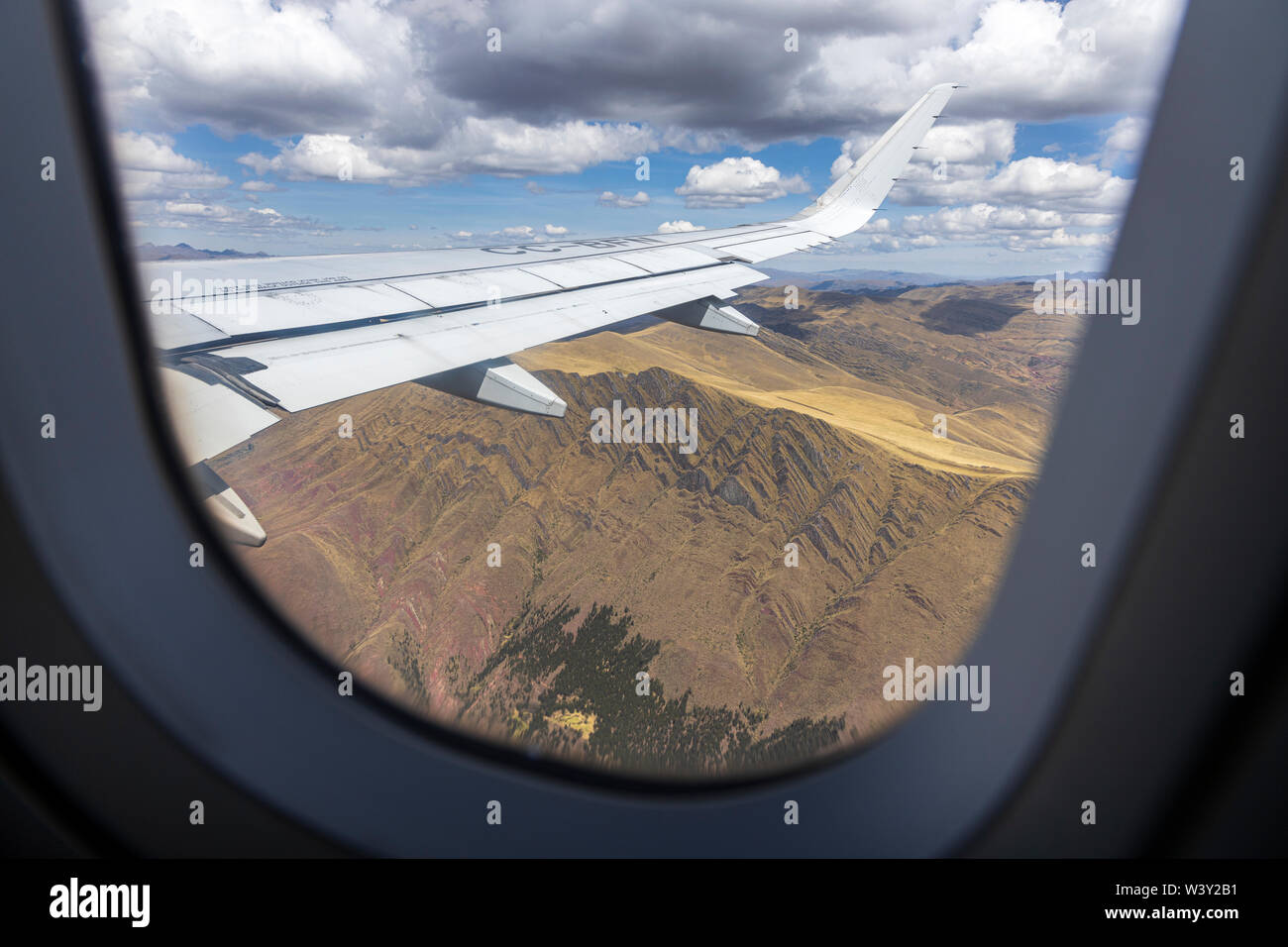 Aerial view over the Andes mountain range from inside a passenger plane ...