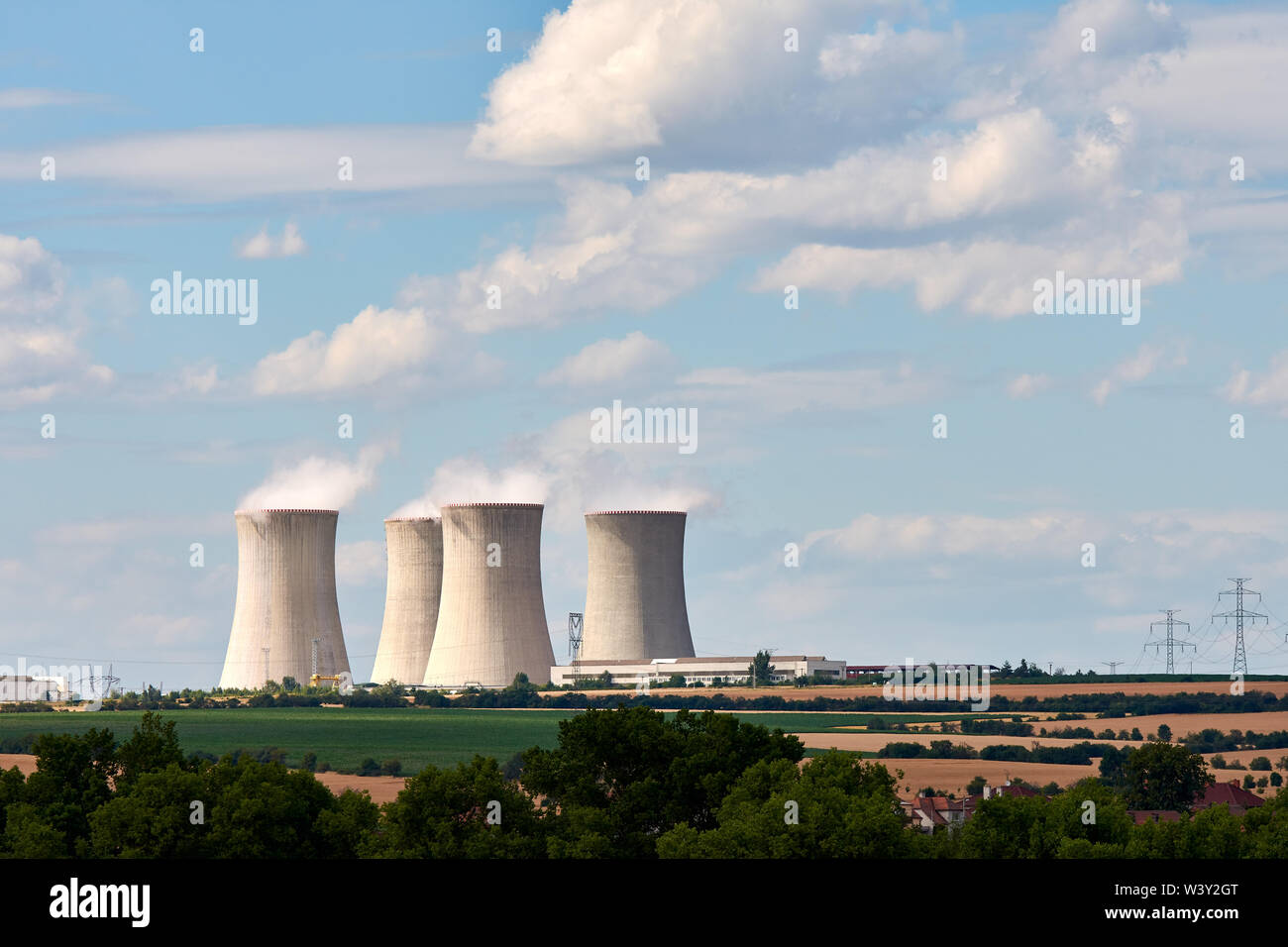 View of smoking chimneys of nuclear power plant, power lines and forest ...