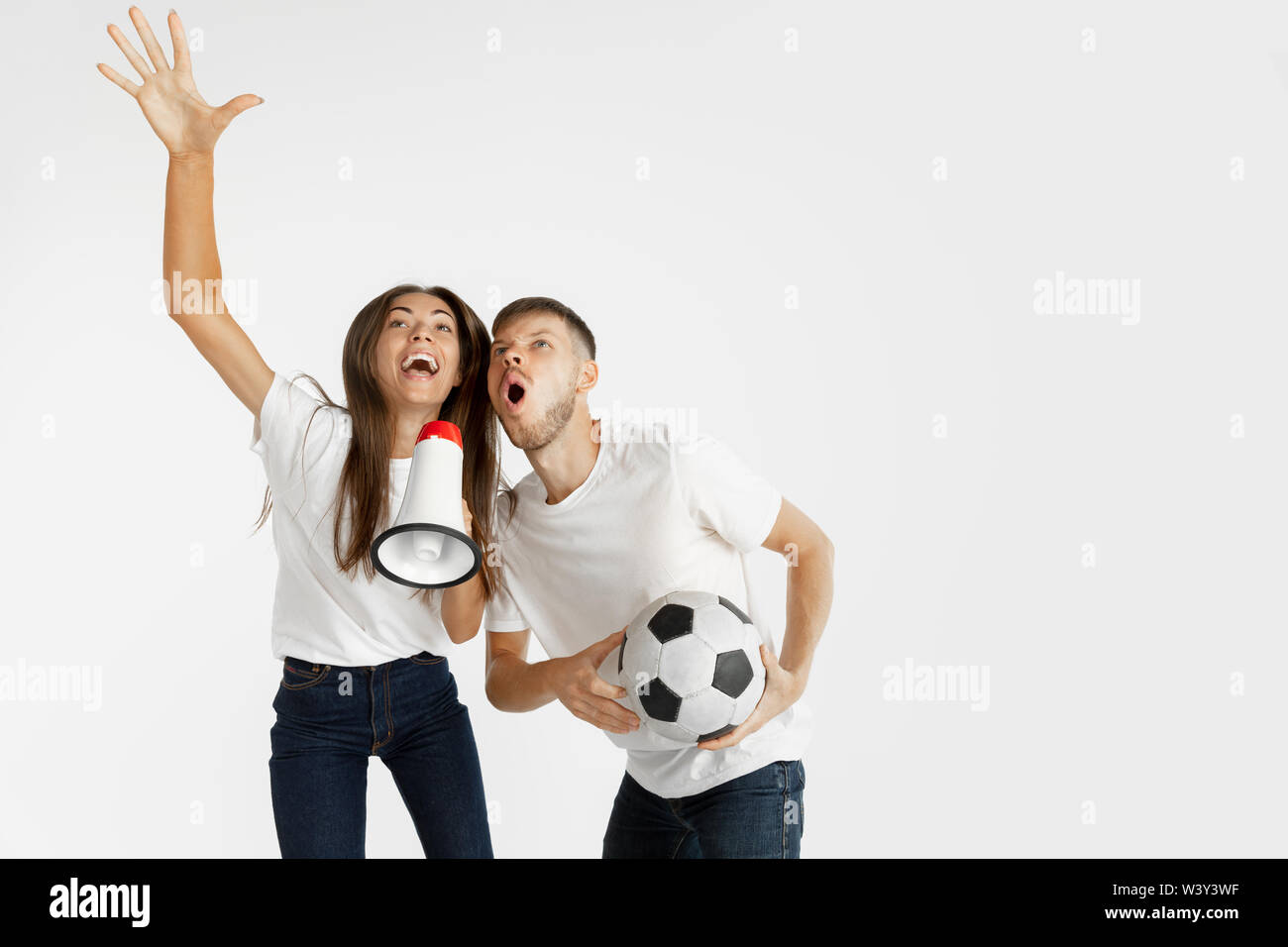 Portrait of beautiful young couple football or soccer fans on white ...