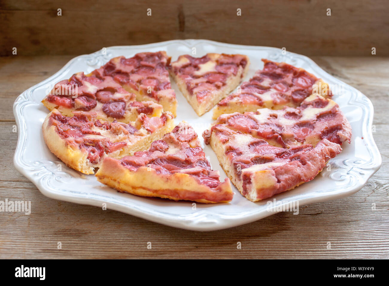 Round strawberry berries tart pie pudding on white plate on rustic ...