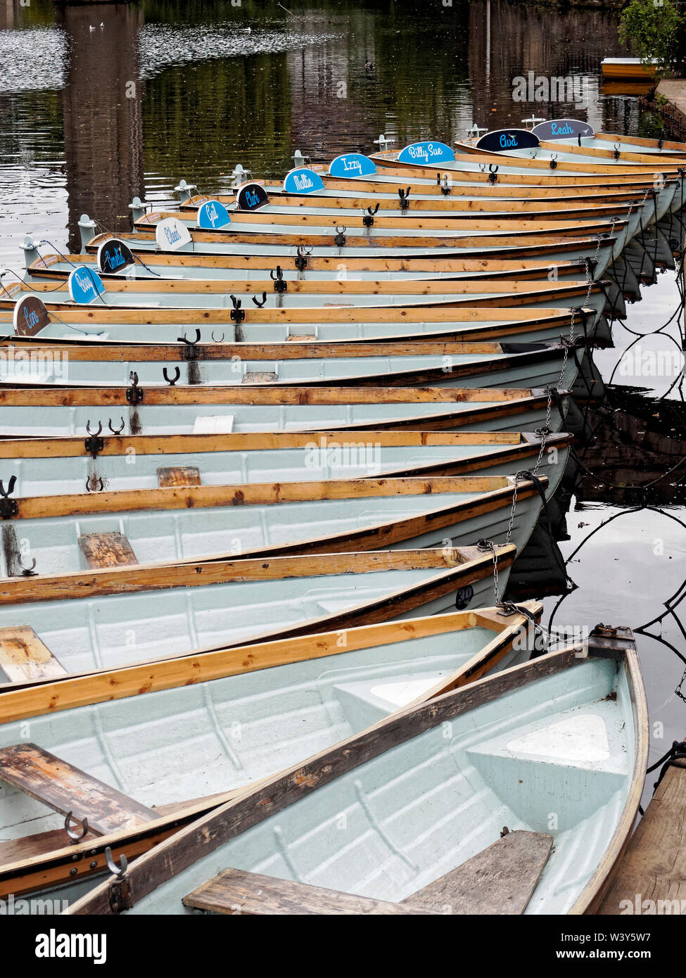Rowing boats for hire tied up alongside a quay on the River Nidd in ...