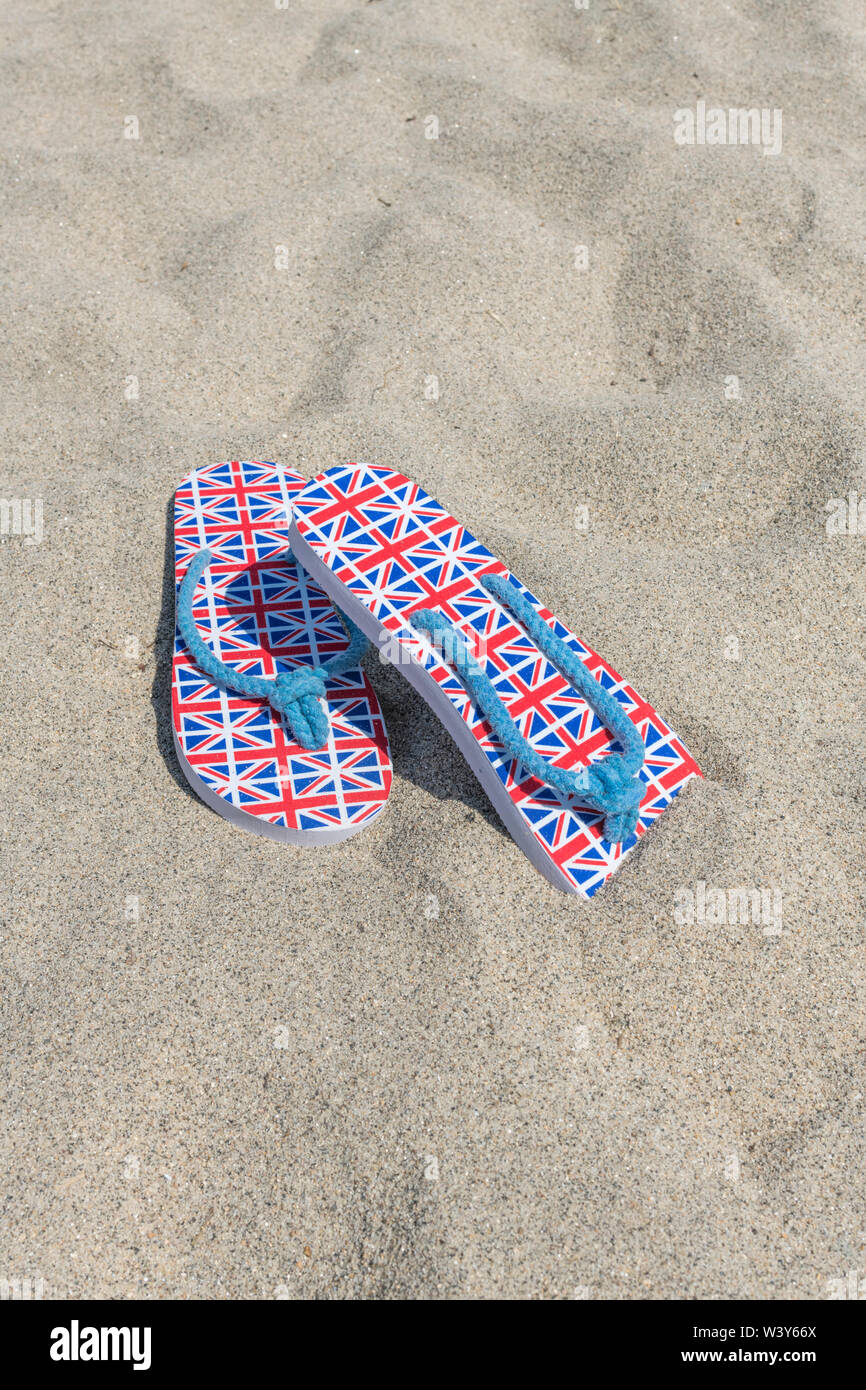 GB flag / Union Jack flip-flops on sandy beach - for 2021 UK staycation ...