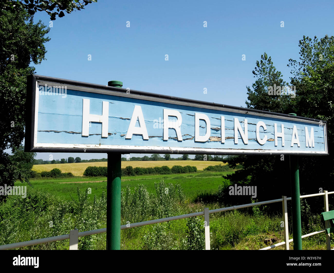 The faded station name board or running-in board at Hardingham Station ...