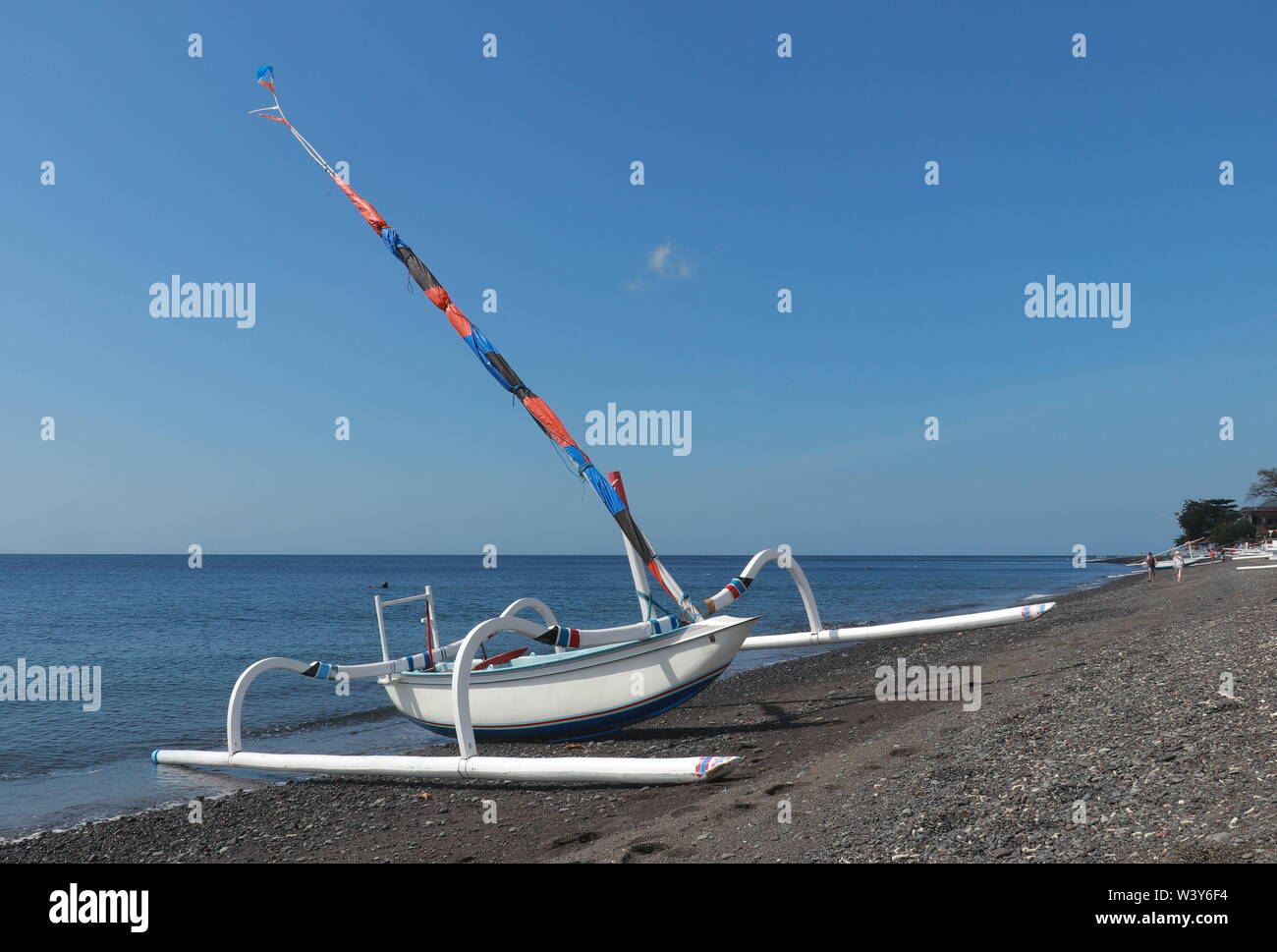Traditional fishing boat jukung with engine and sail. Balinese boat ...