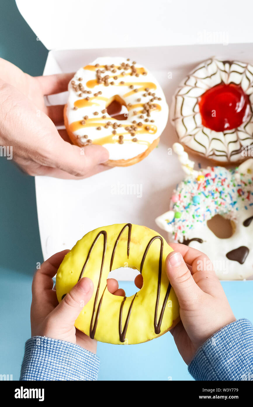 People hands takes donuts from donuts box over blue background. Family ...