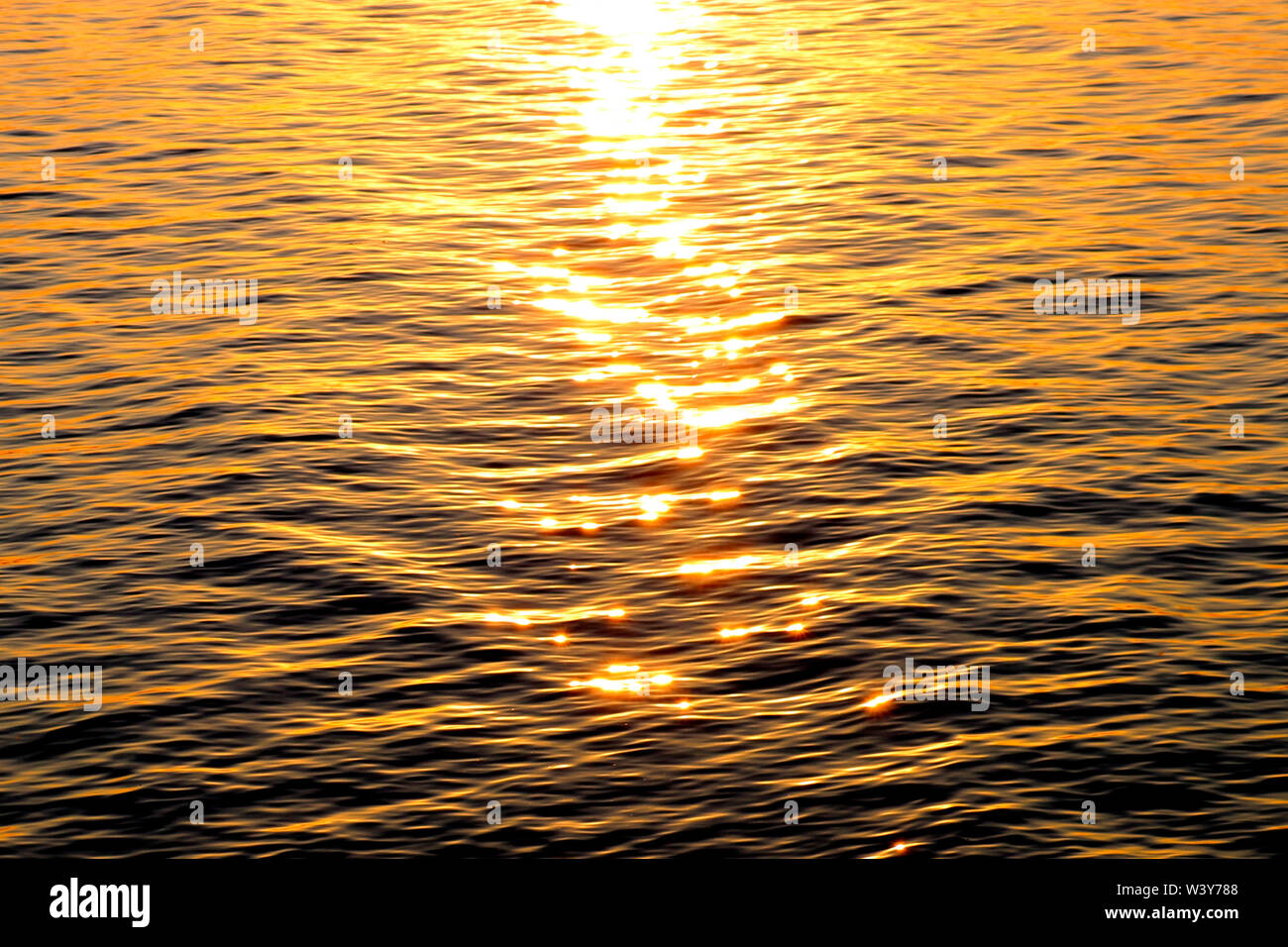 Texture of ripples on the water with bright sun highlights during ...