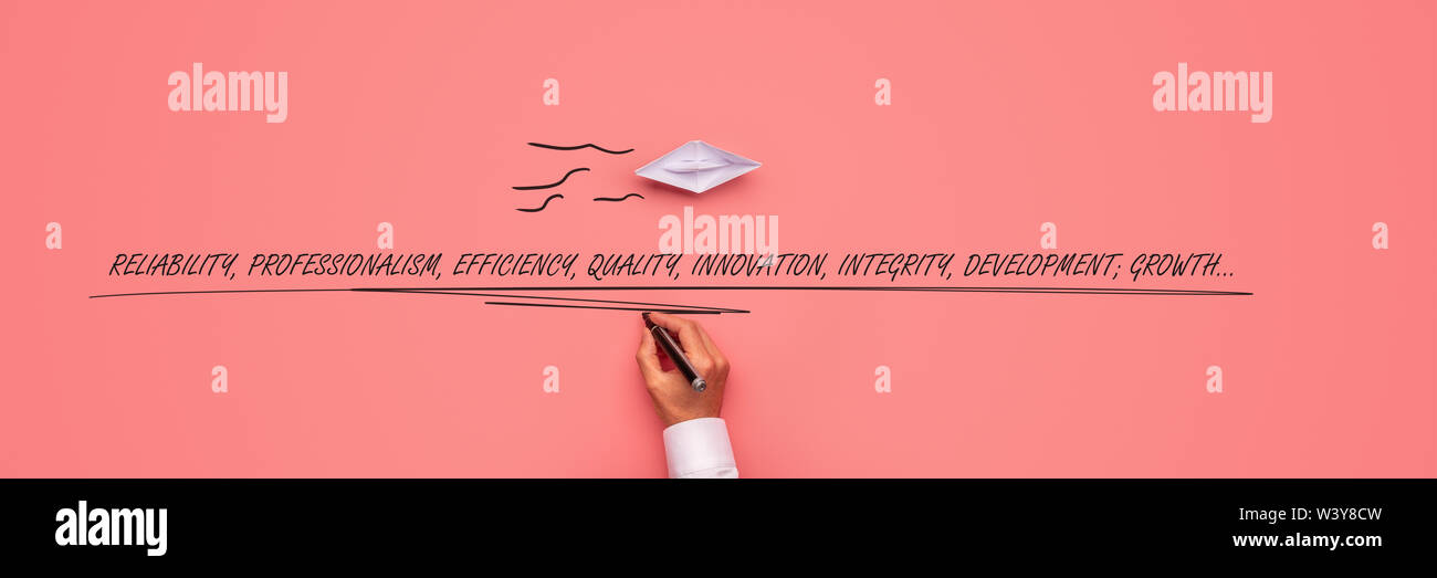 Origami paper boat over pink background with male hand writing words of ...