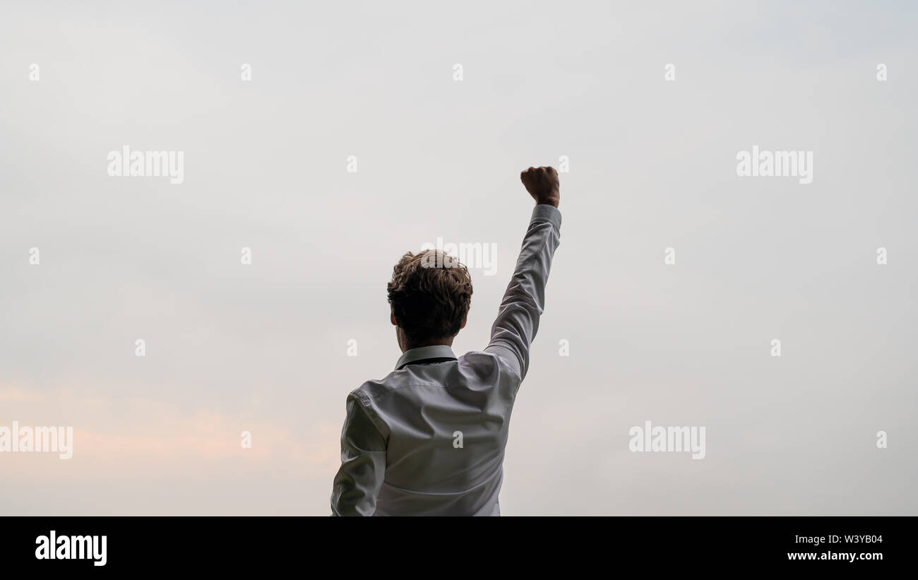 Back view man raised fist hi-res stock photography and images - Alamy