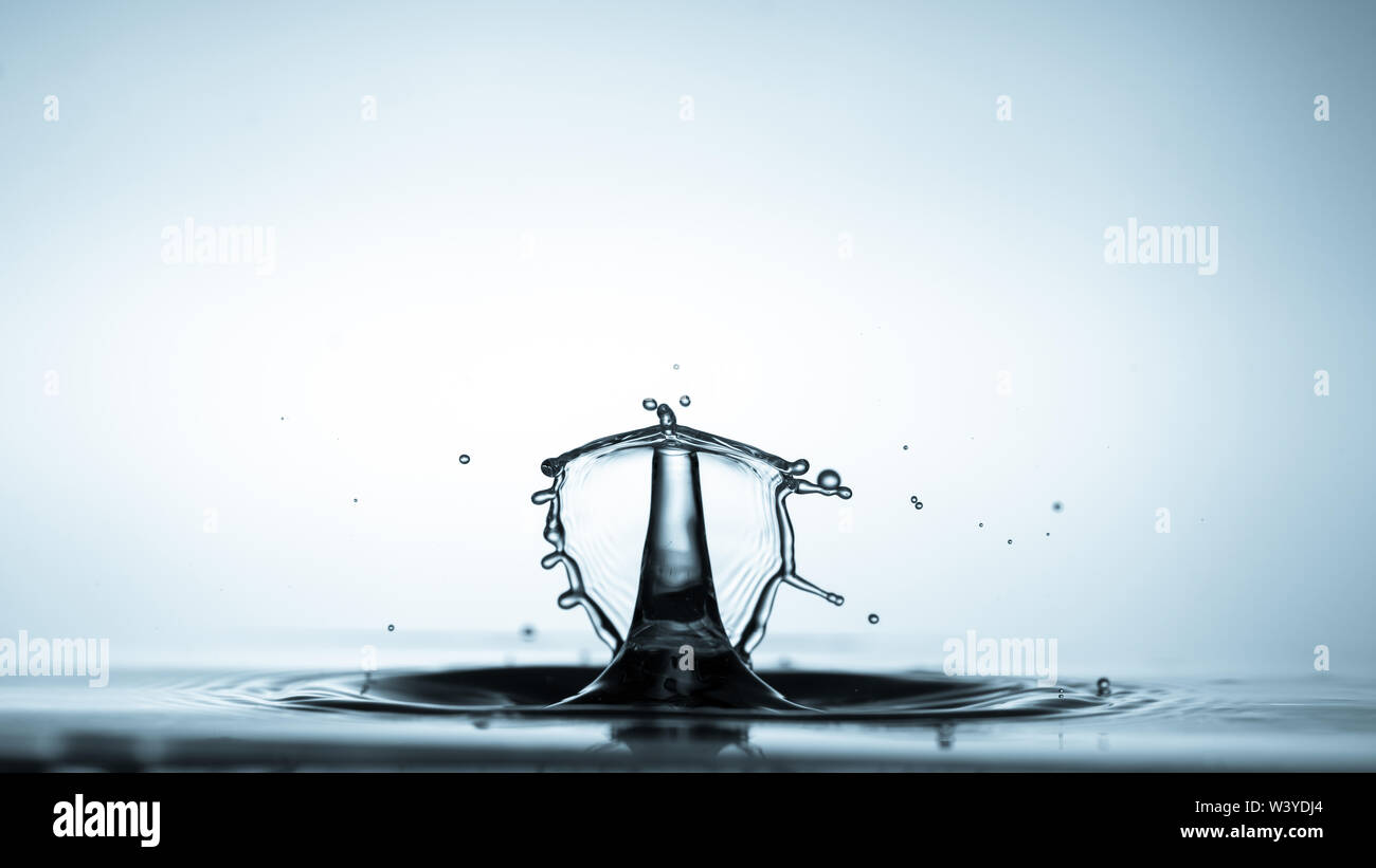 Close-up of a water drop falling on water surface Stock Photo - Alamy