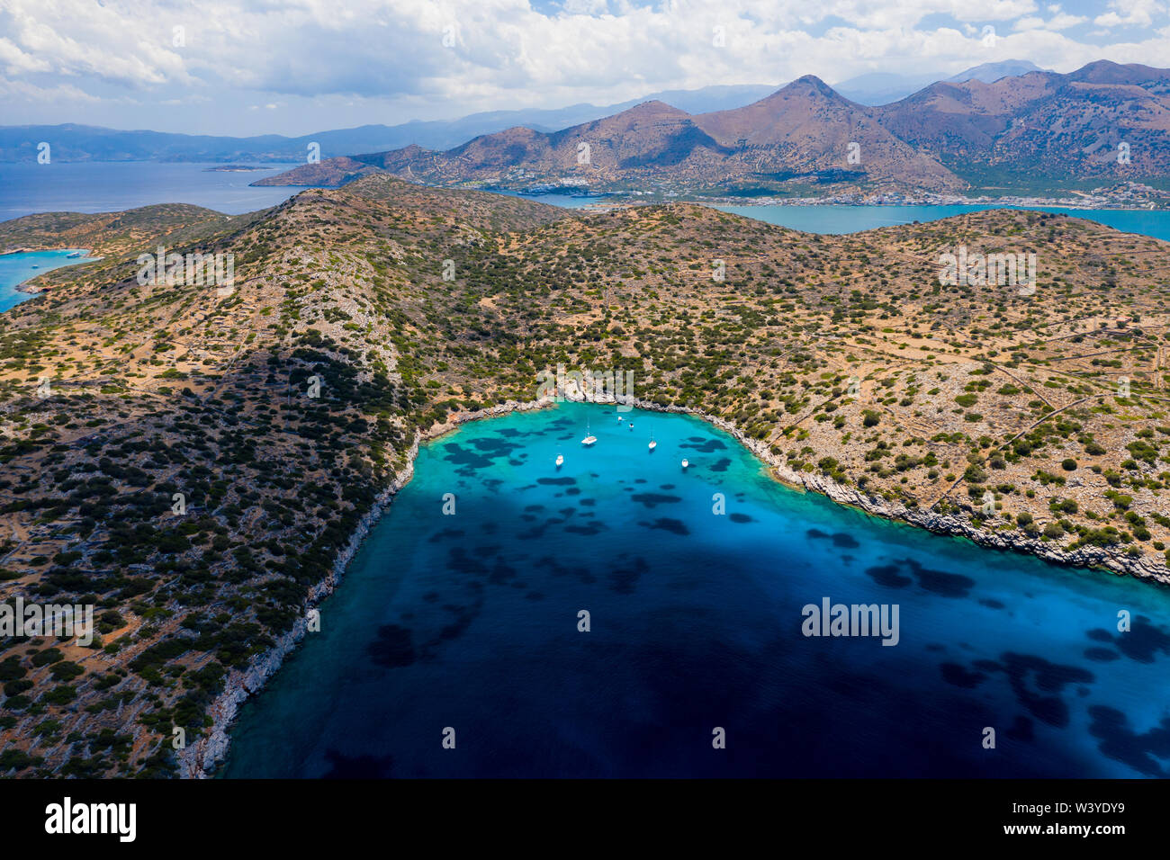 Aerial view of a clear, deep blue ocean and dry, yellow summer ...