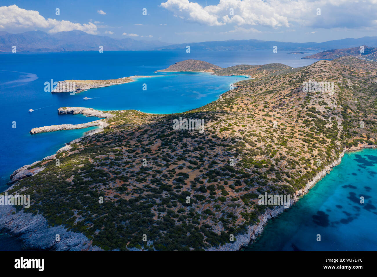 Aerial view of a clear, deep blue ocean and dry, yellow summer ...