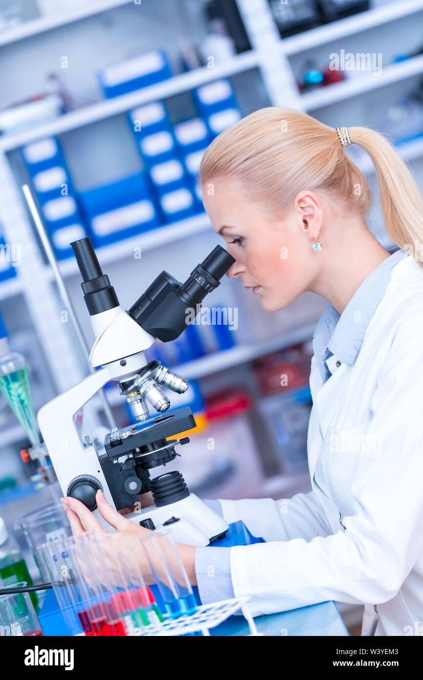 Girl with a slide for the microscope University Hospital. Attractive ...