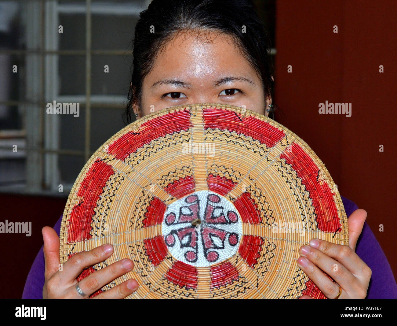 Young Malaysian Bidayuh woman with beautiful eyes hides her lower face ...