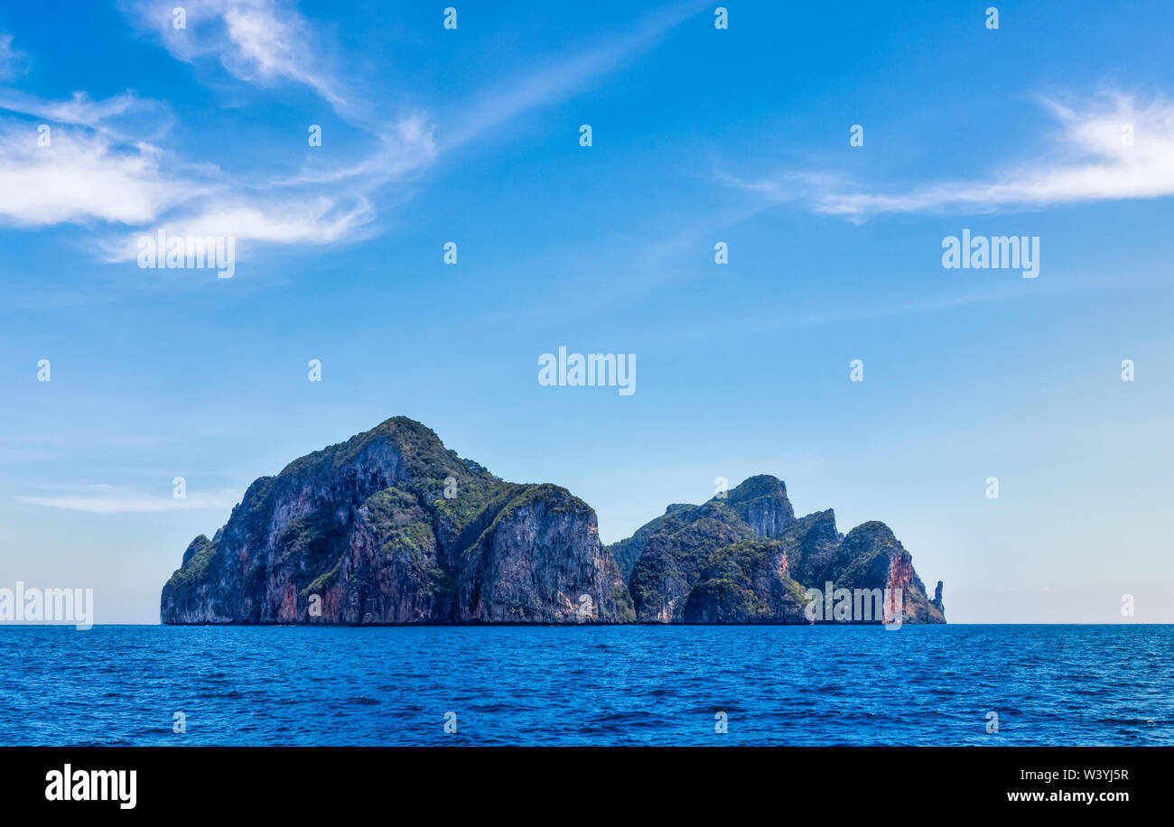 Phi Phi Lay island with tall cliffs and mountains, blue shy and white ...