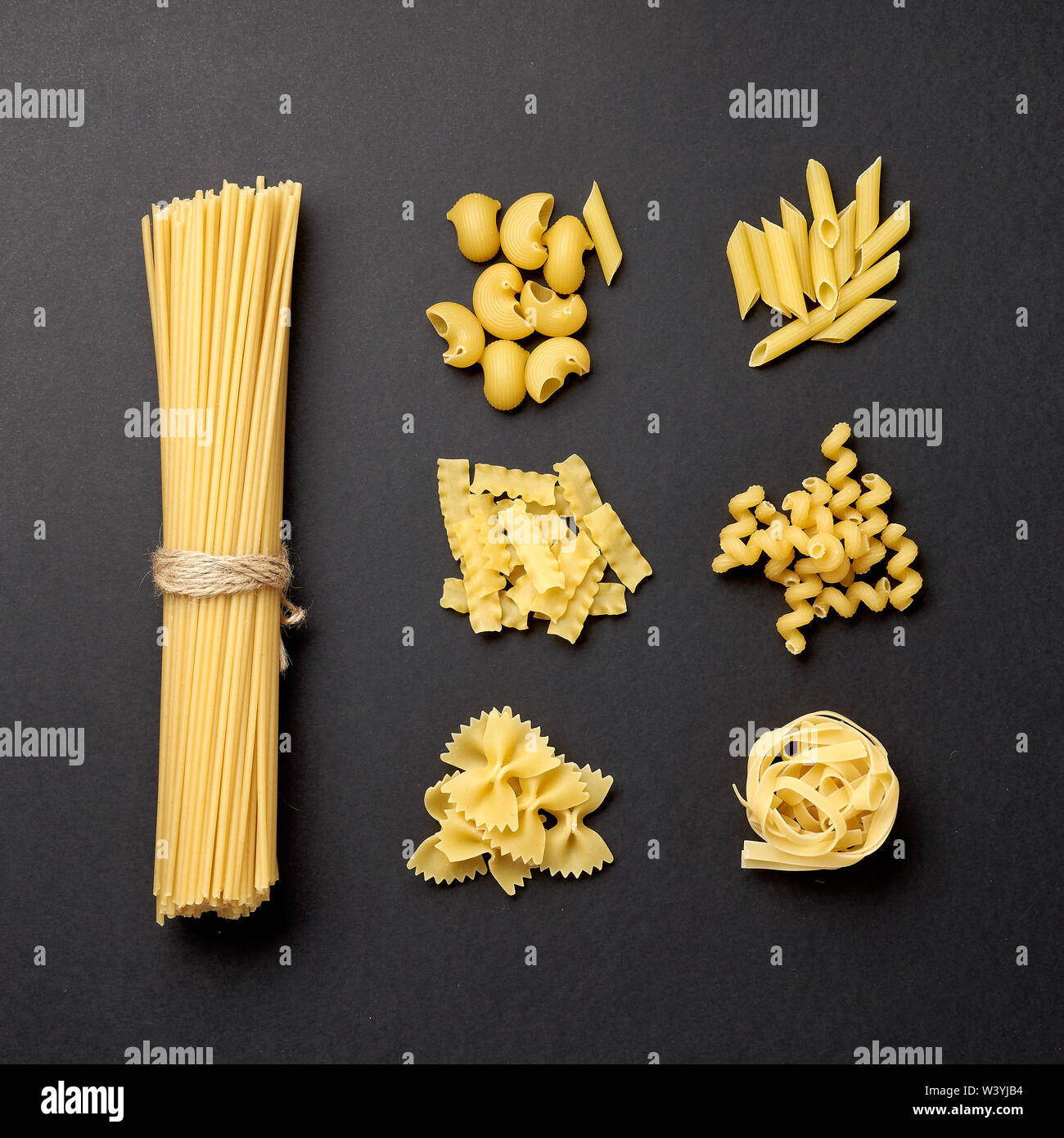 Assorted types of pasta on black background. Top view. Various forms of ...
