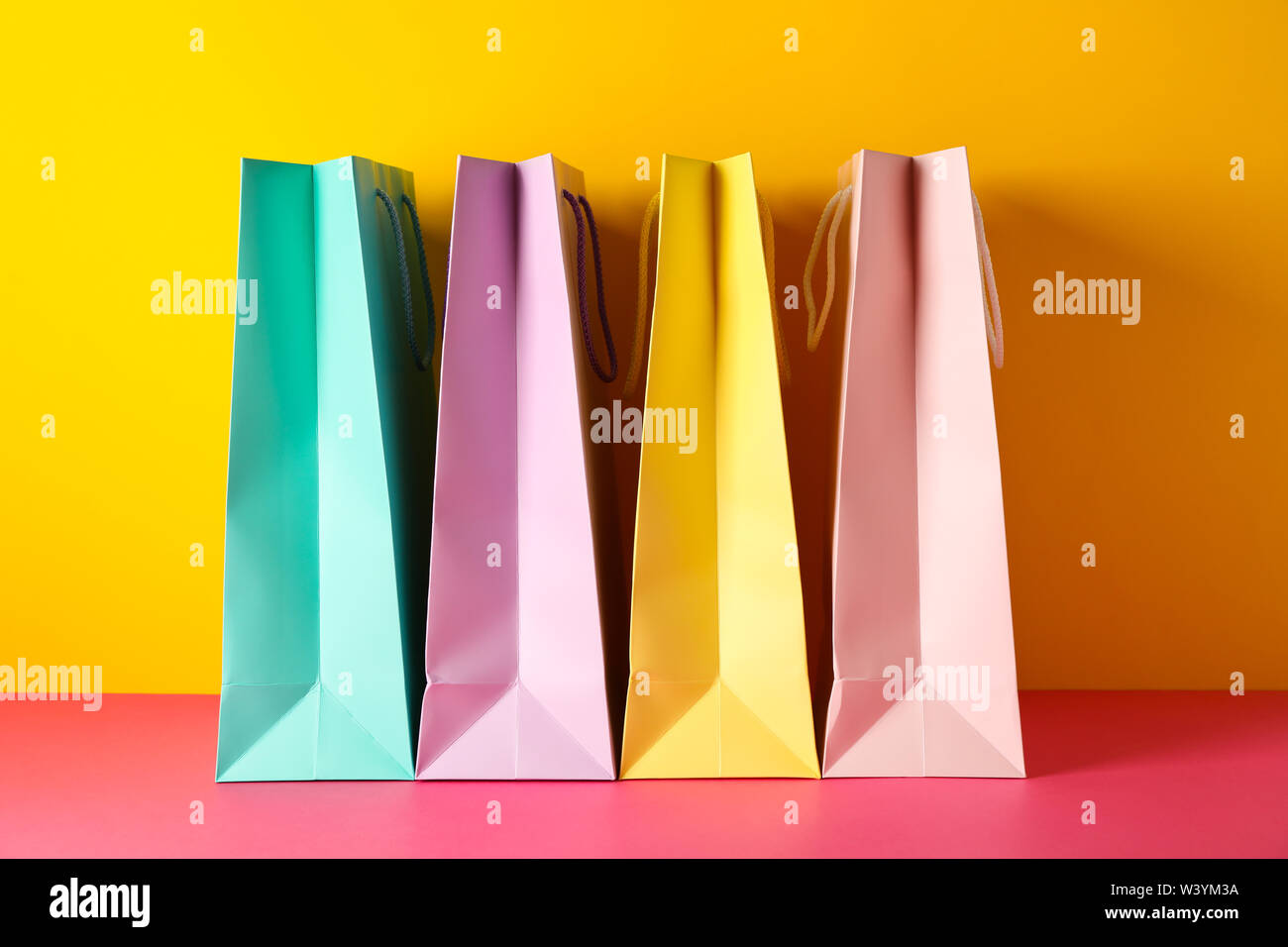 Color paper bags on multicolor background, space for text Stock Photo ...