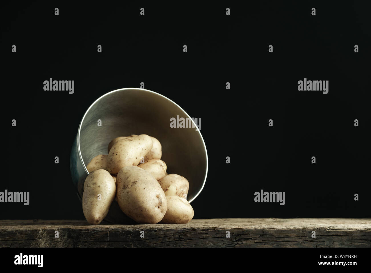 Fresh potato in silver bowl on a old oak wooden table and beautiful ...