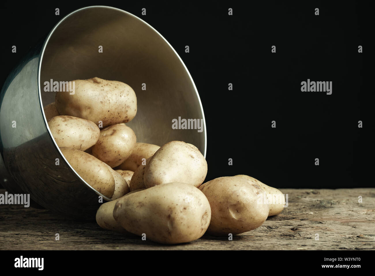 Fresh potato in silver bowl on a old oak wooden table and beautiful ...