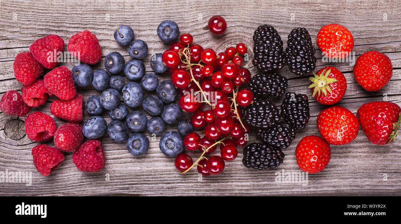 set of fresh forest fruits arranged on rustic wooden table Stock Photo ...