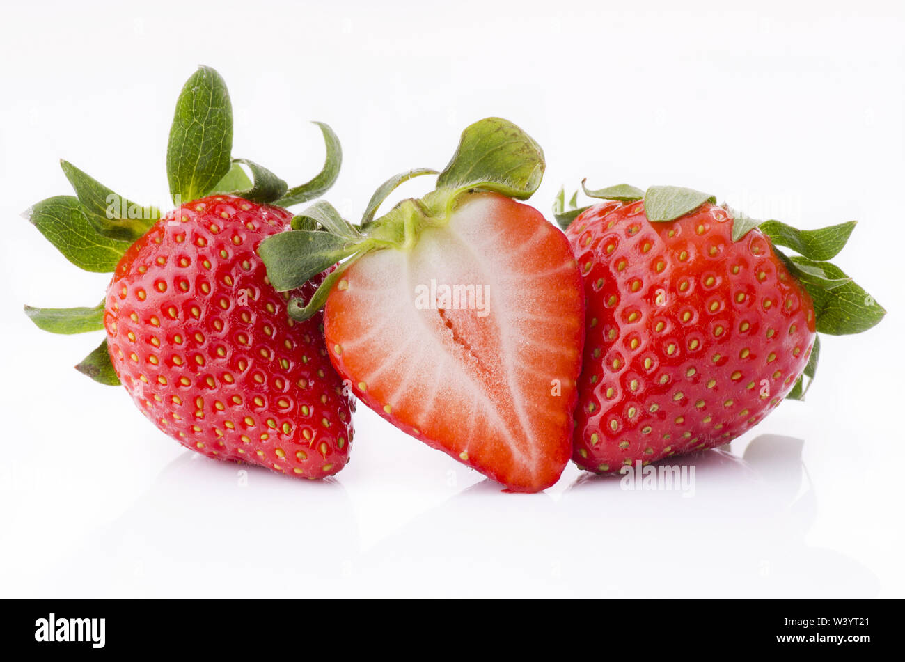 macro of fresh whole strawberries and sliced on the white background ...