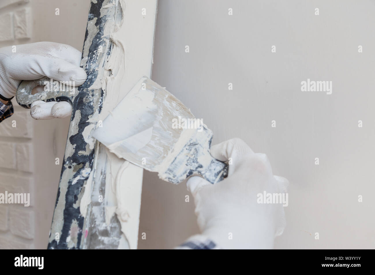 Putty the wall gypsum putty with spatulas Stock Photo - Alamy