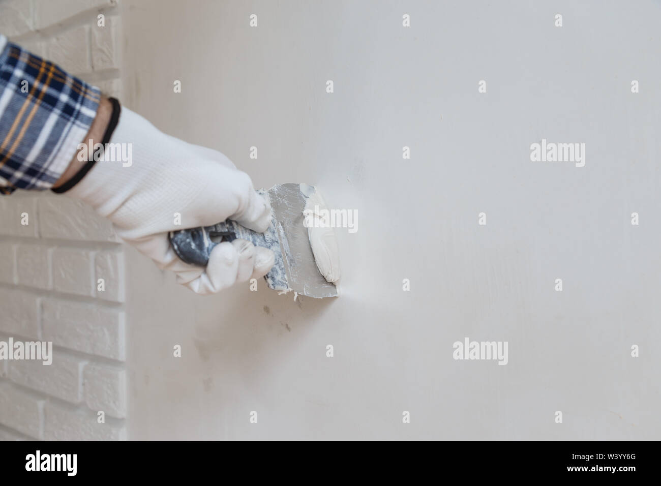 Putty the wall gypsum putty with spatulas Stock Photo - Alamy