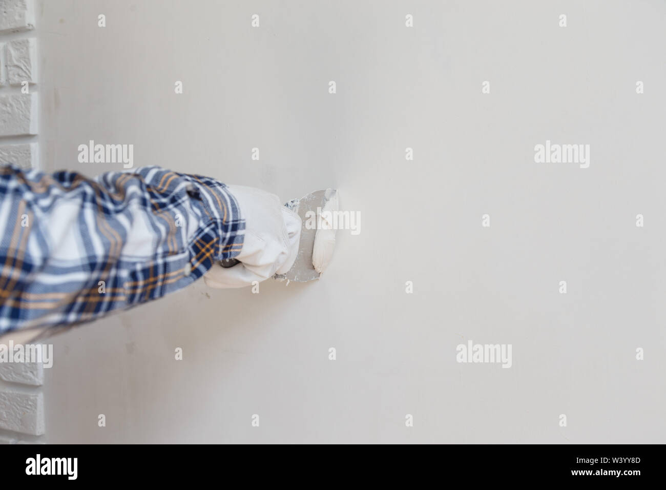 Putty the wall gypsum putty with spatulas Stock Photo - Alamy