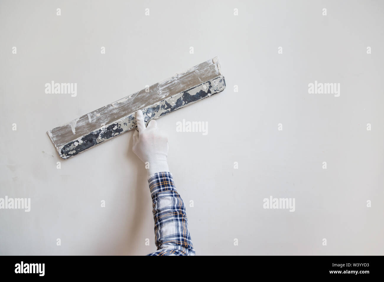 Putty the wall gypsum putty with spatulas Stock Photo - Alamy
