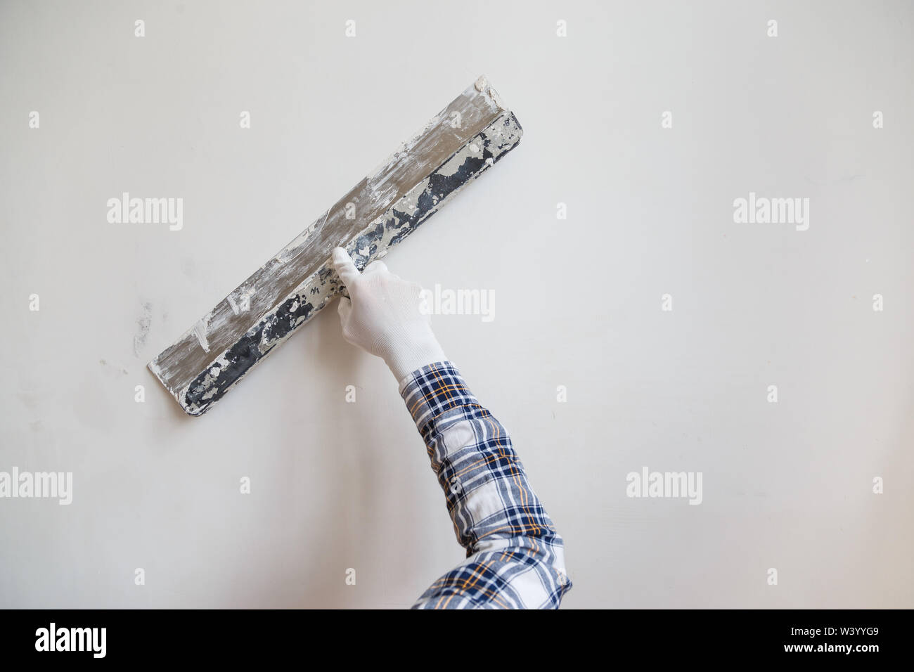 Putty the wall gypsum putty with spatulas Stock Photo - Alamy