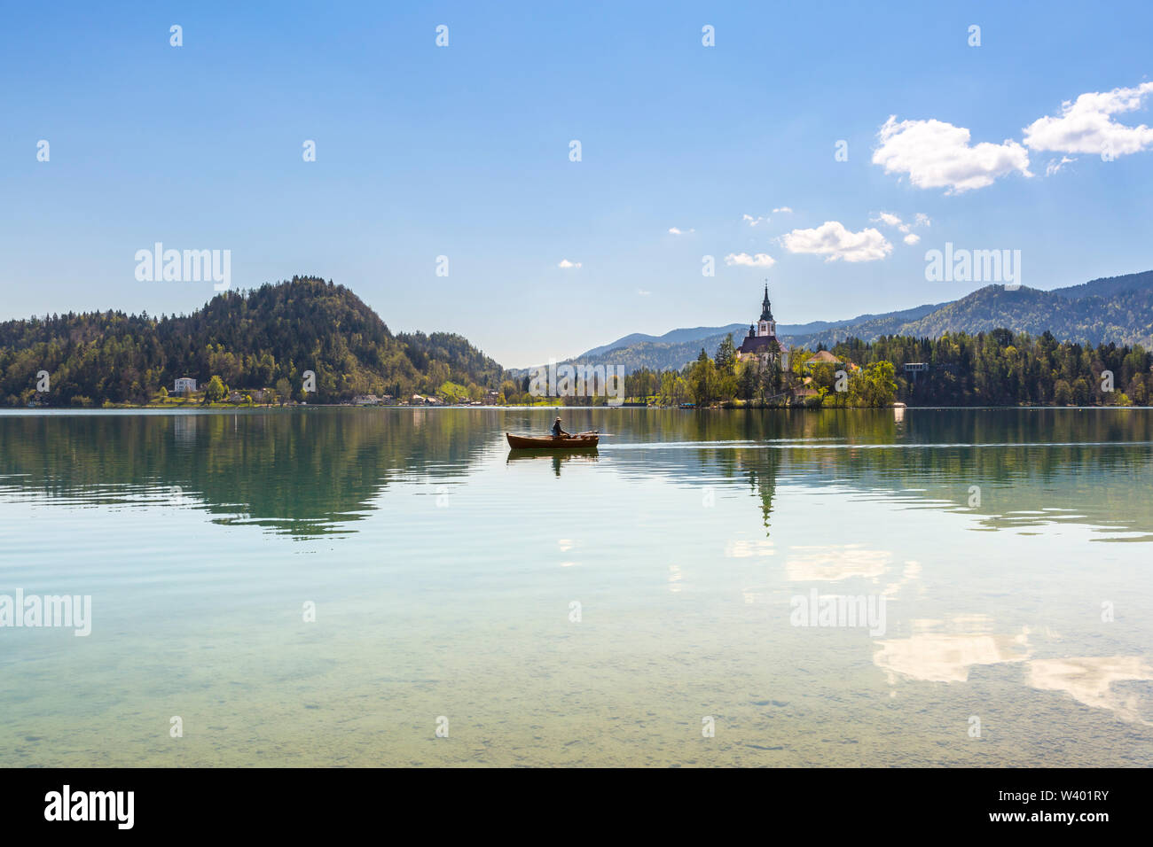A man rowing across Lake Bled on a sunny spring morning Stock Photo - Alamy