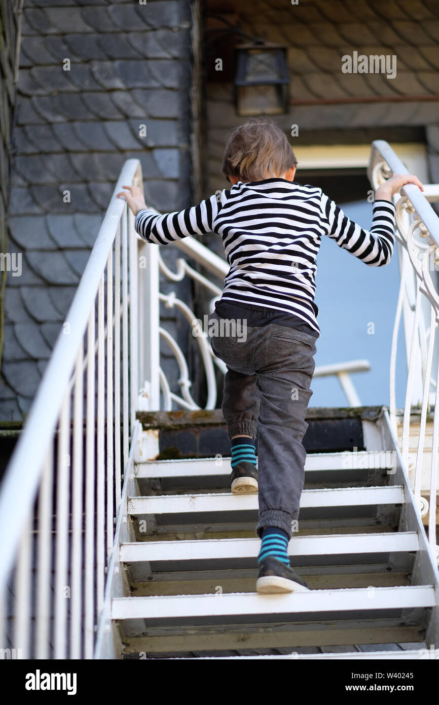 A child climbs up a metal ladder Stock Photo - Alamy